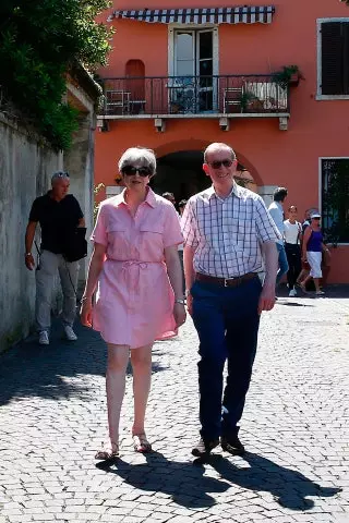 Theresa May in die Switserse Alpe of die Gardameer. Hierdie vakansies klink baie soos dié van Gordon Browns wat in die amp regeer....