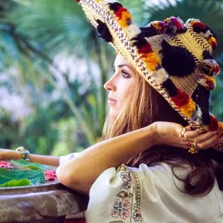 Talitha Getty de perfil usando um chapéu de palha estilo sombrero no terreno de sua casa em Marrakesh 1970