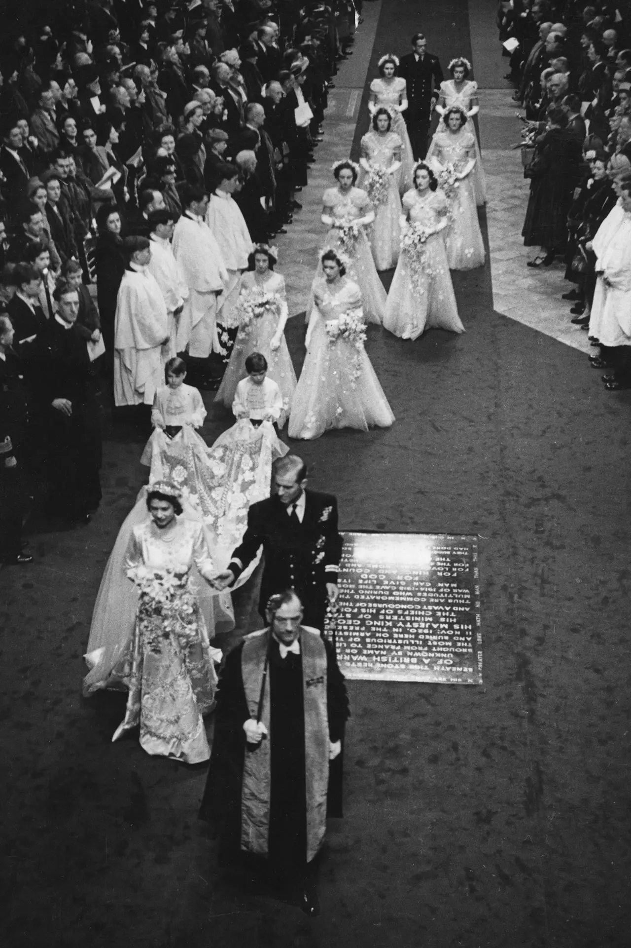 Prinsesse Elizabeth og prins Philip går ned ad gangen i Westminster Abbey efterfulgt af deres brudepiger og sider