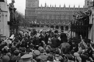 Le Premier ministre Winston Churchill salue les foules enthousiastes qui se sont rassemblées devant les chambres du Parlement le jour de la victoire