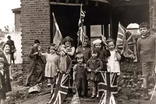 I bambini in una bomba hanno segnato Battersea nel sud di Londra con le loro bandiere Union Jack