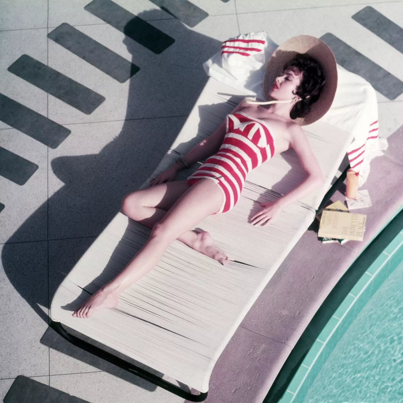 Mara Lane lounging by a pool 1954