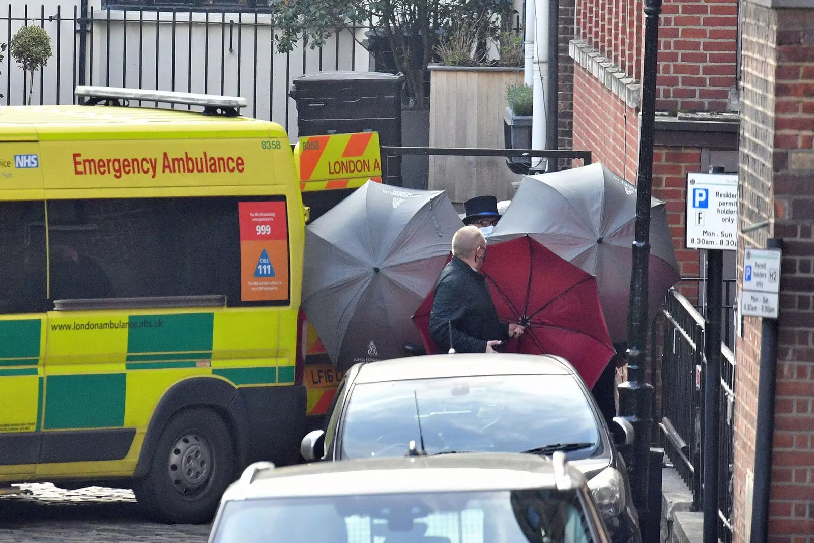 Personeel van het King Edward VII-ziekenhuis in Londen gebruikt paraplu's om iemand te beschermen waarvan wordt gedacht dat het de hertog van Edinburgh is...