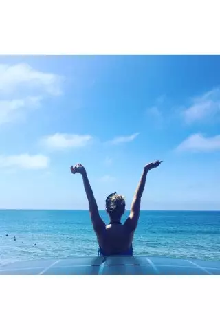 Poppy Jamie wirft ihre Hände in die Luft, um den YMCA in Malibu zu gründen