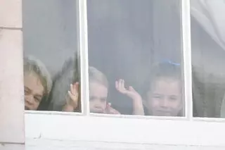 El príncipe George, el príncipe Louis y la princesa Charlotte, miran a través de la ventana del Palacio de Buckingham