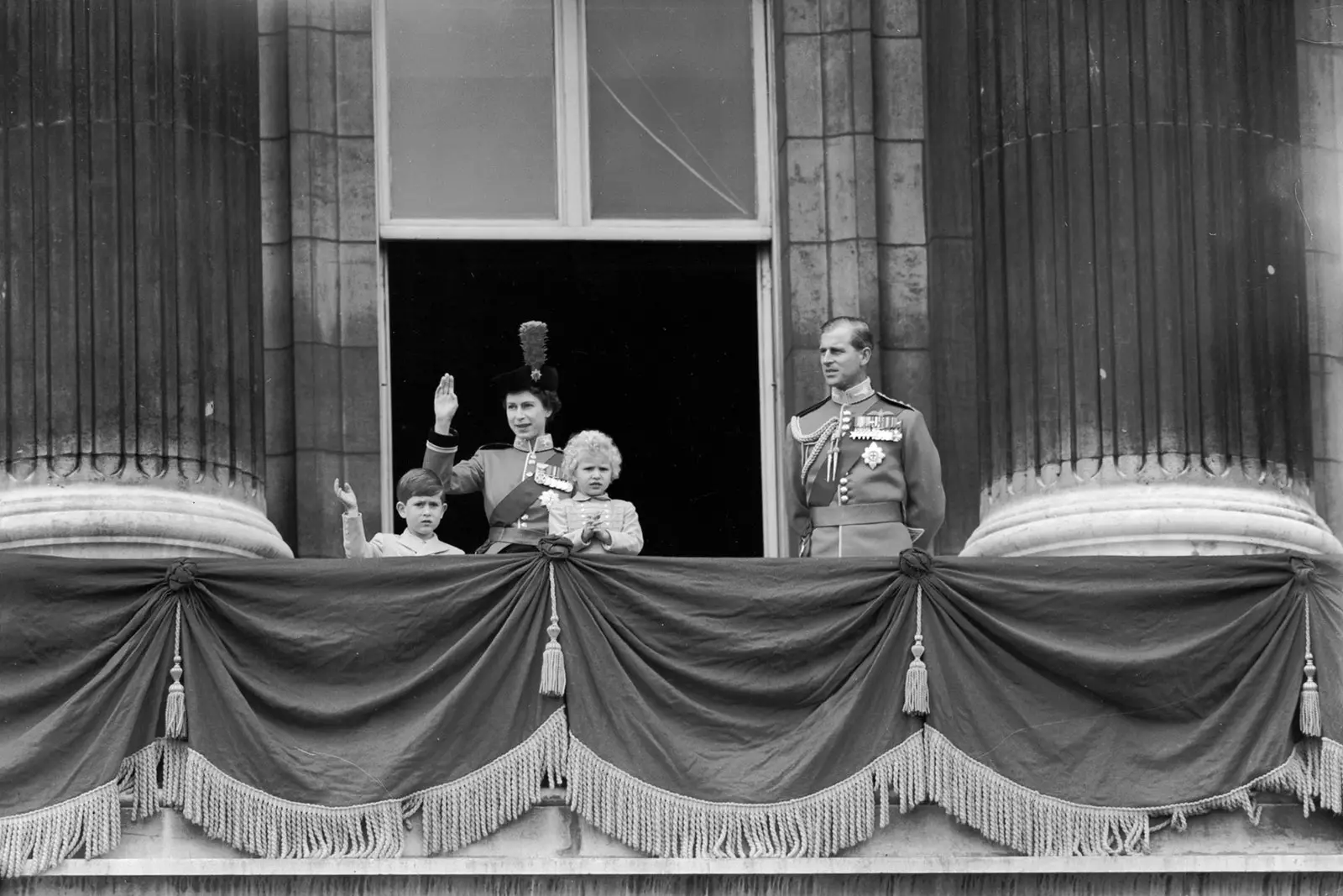 Şa aýal, 1954-nji ýylda şazada Filip we olaryň çagalary Şazada Çarlz we şazada Anne bilen balkonda märekä el çarpdy