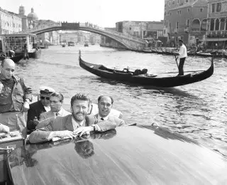 Kirk Douglas met baard op 'n motorlansering in Venesië ná sy aankoms per spoor vanaf Rome vir die vertoning van Hollywood se...