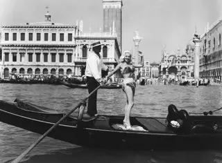 Diana Dors e veshur me bikini vizon ndërsa hipte në një gondolë përtej Sheshin e Shën Markut gjatë Festivalit të Filmit në Venecia, 5 maj 1955